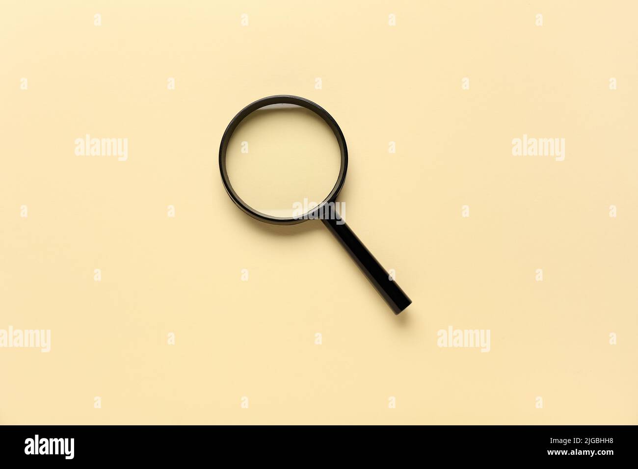 Magnifying glass on beige background Stock Photo - Alamy