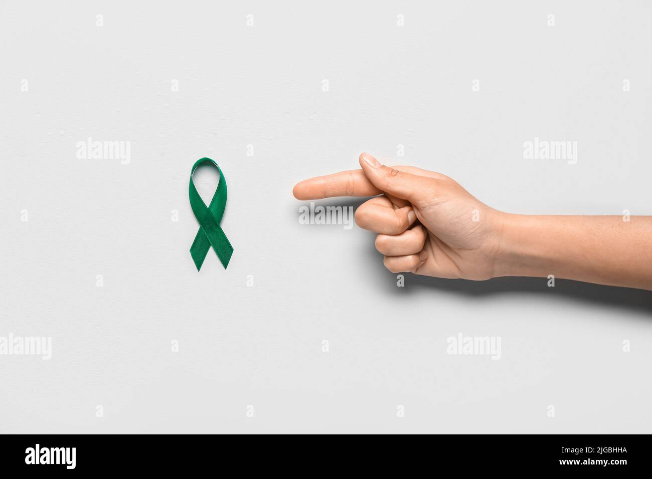Hand and green ribbon on light background. Liver cancer concept Stock ...