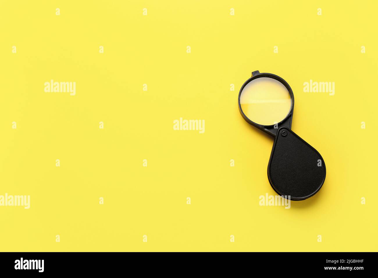 Magnifying glass on yellow background Stock Photo - Alamy