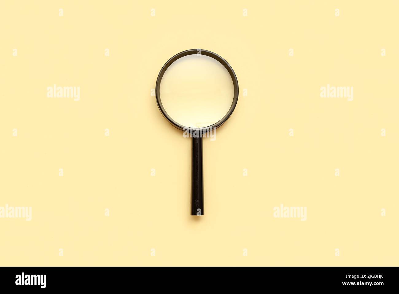 Magnifying glass on beige background Stock Photo - Alamy