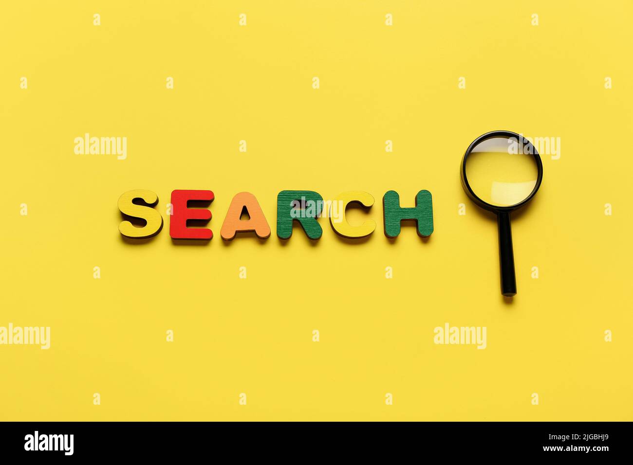Magnifying glass and word SEARCH on yellow background Stock Photo - Alamy