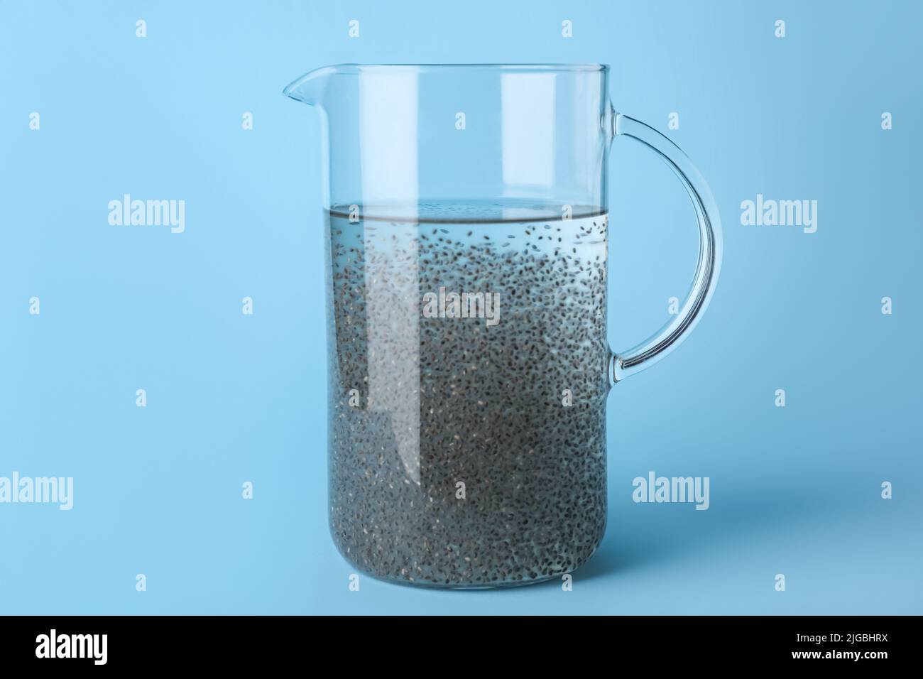 Glass pitcher of water with chia seeds on color background Stock Photo ...