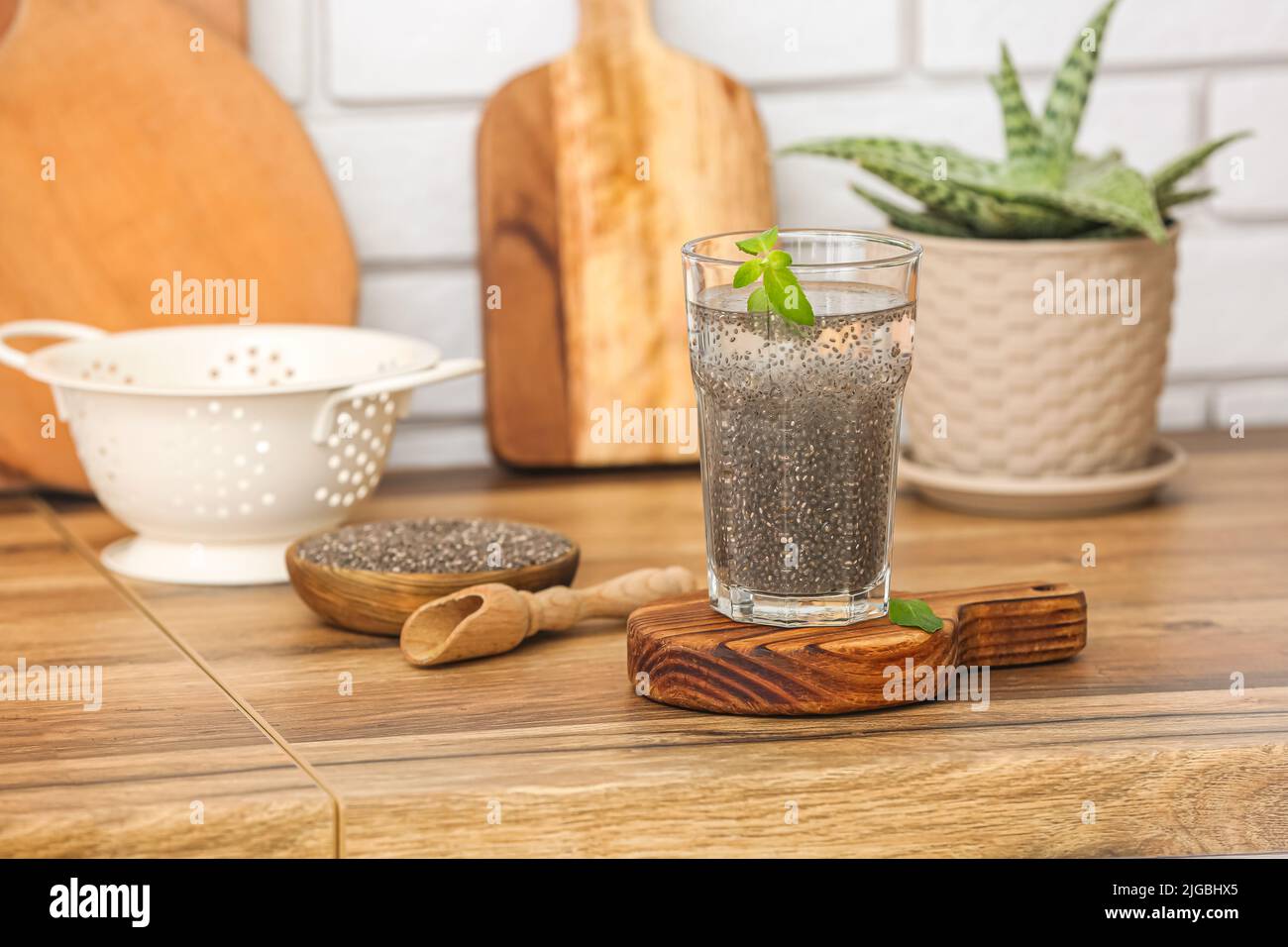 Glass of water, scoop and bowl with chia seeds on counter in kitchen ...
