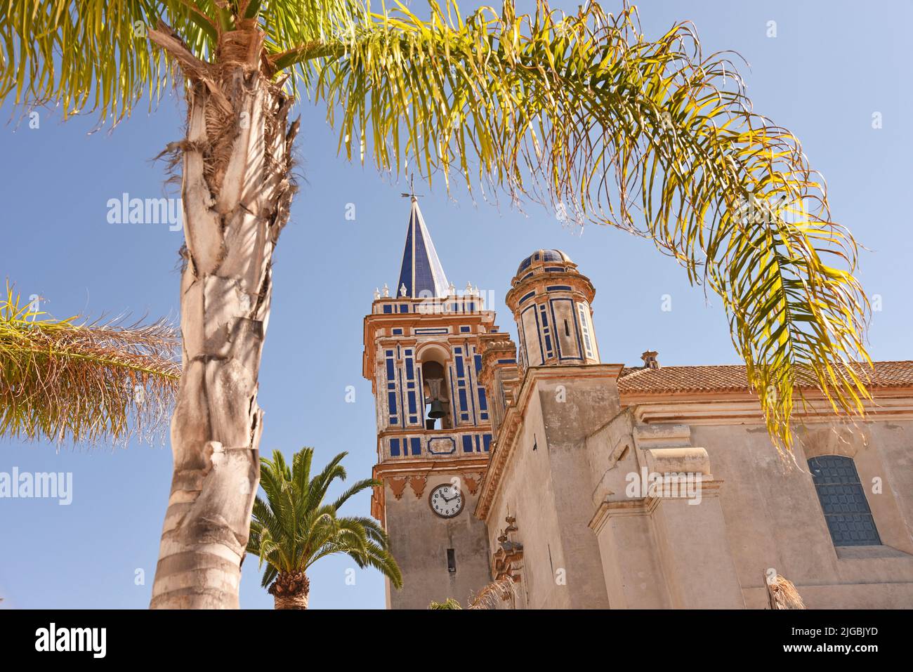 Tower of a little church under the branch of a palm tree Stock Photo ...