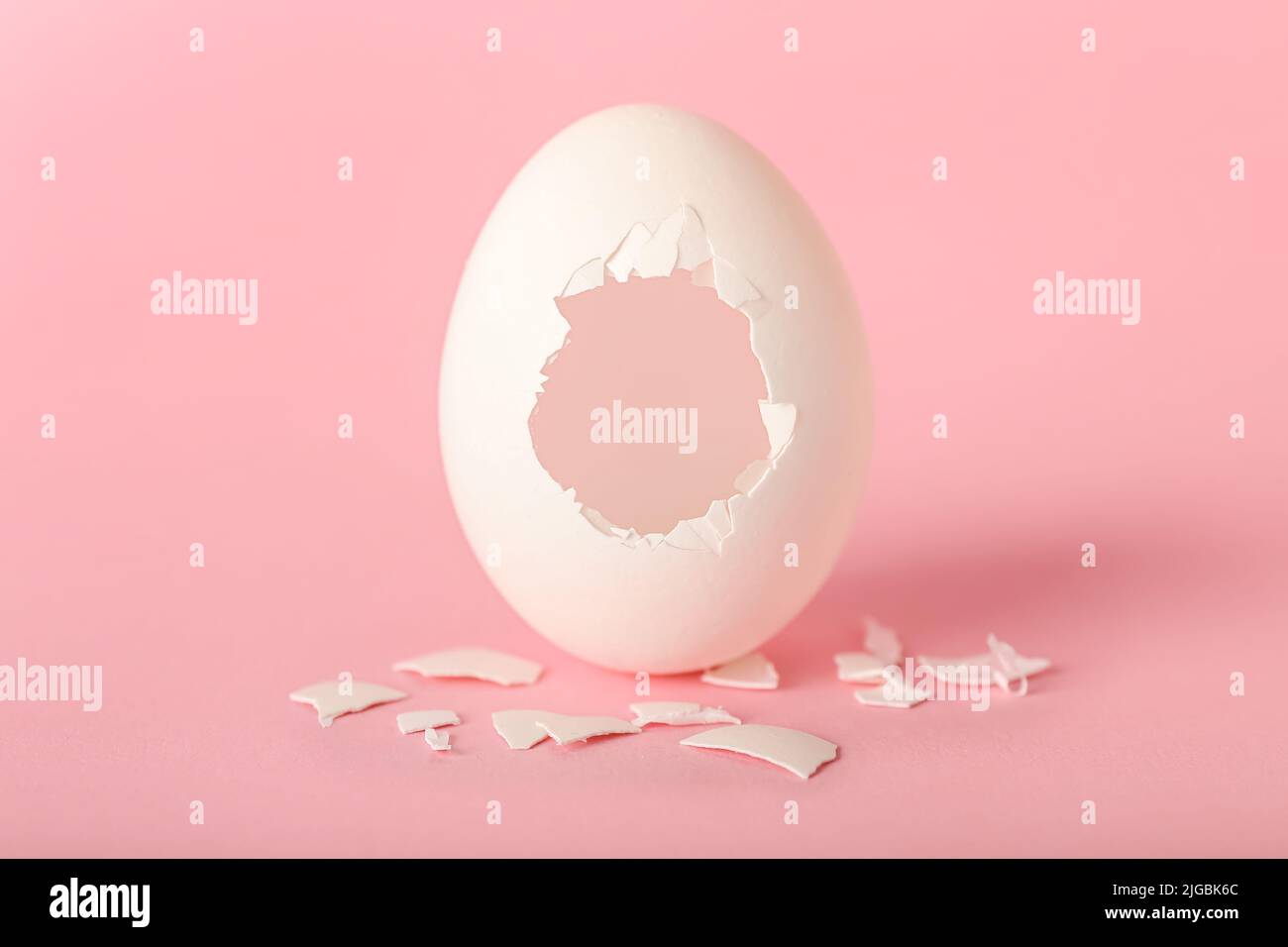 Cracked egg shell on pink background Stock Photo - Alamy