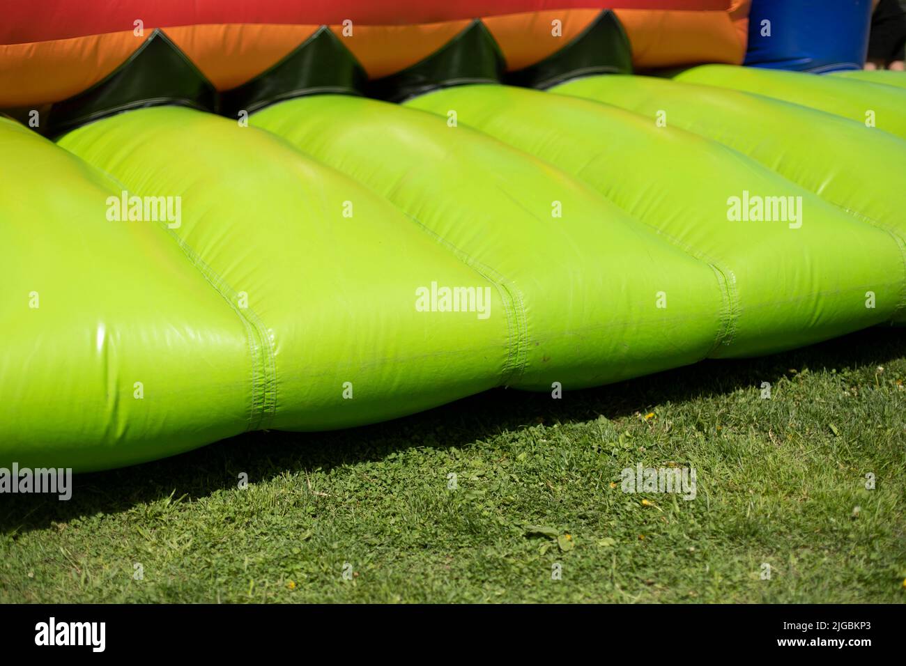 Inflatable trampoline. Amusement park. Green rubber. Obstacle bar in ...