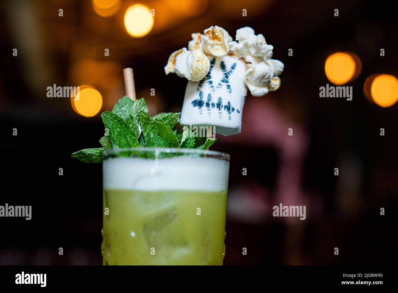 Close-up of frothy cocktail with marshmallow topper in glass at ...