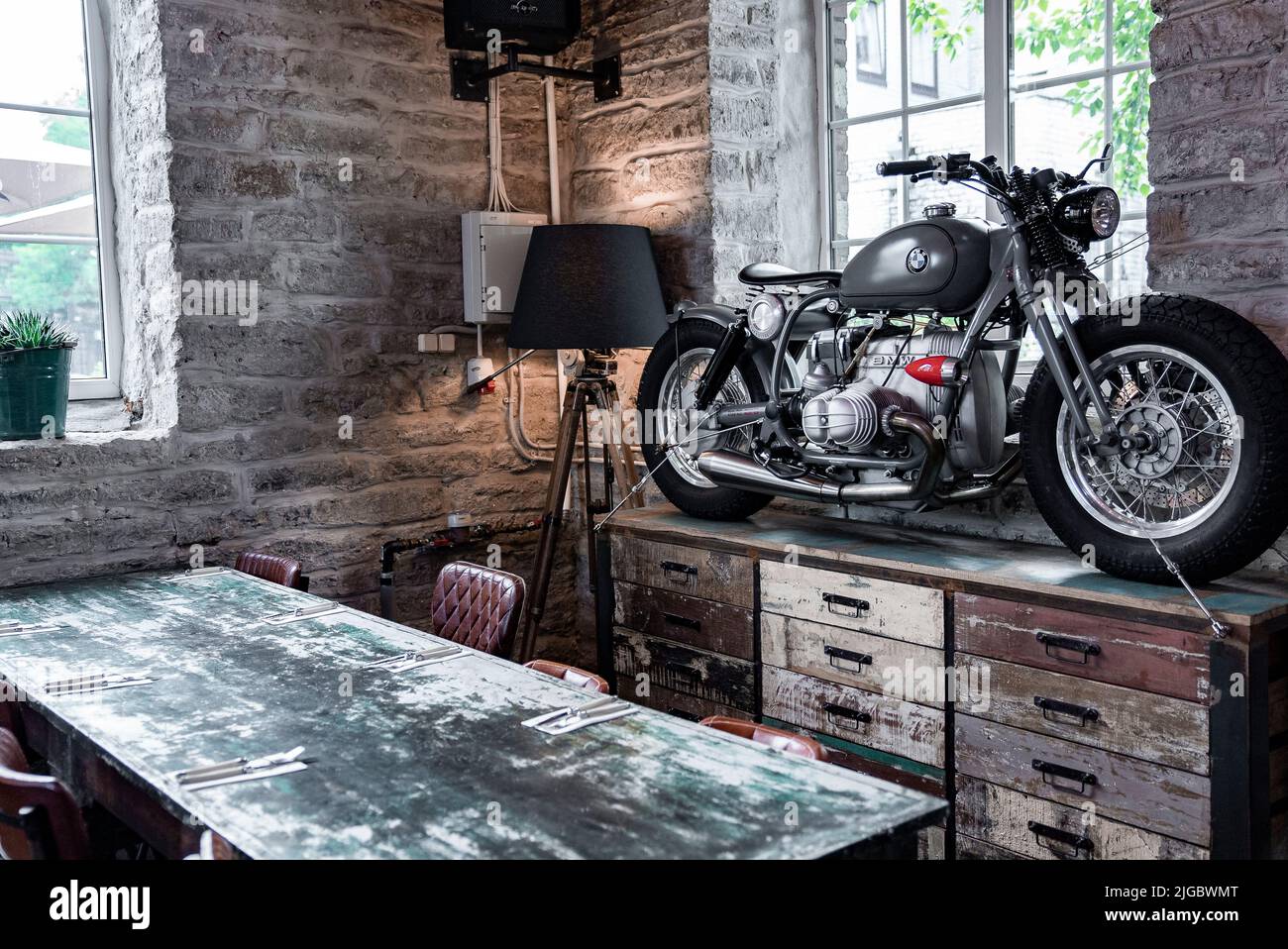 Motorcycle on old table by lamp against window in One sixty smokehouse ...
