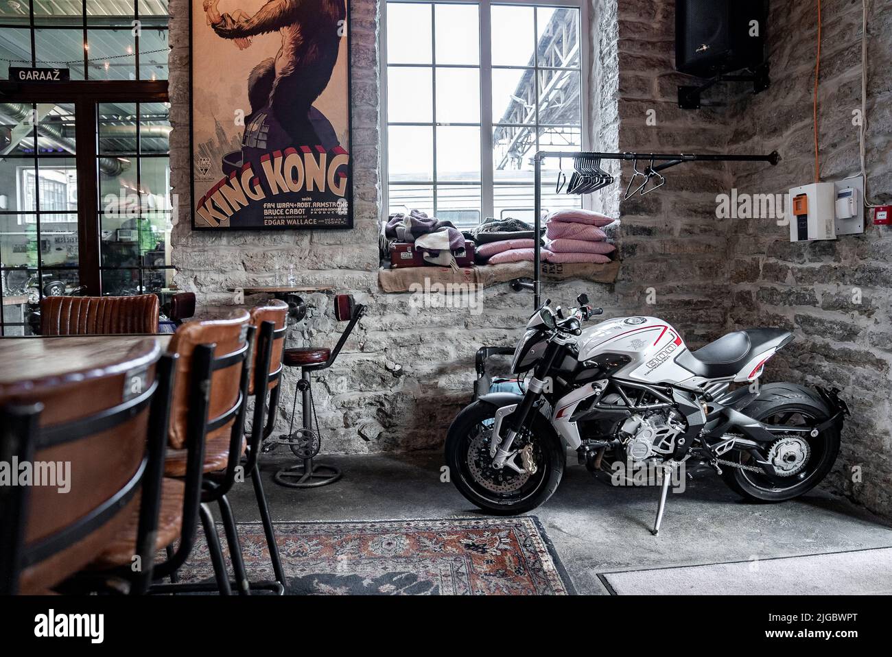 White motorcycle by tables and chairs against window in One sixty ...