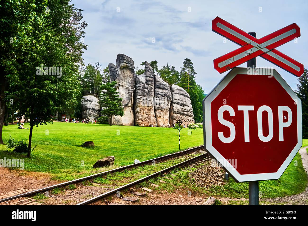 Stop sign in front of narrow-gauge railroad at a group of sandstone ...