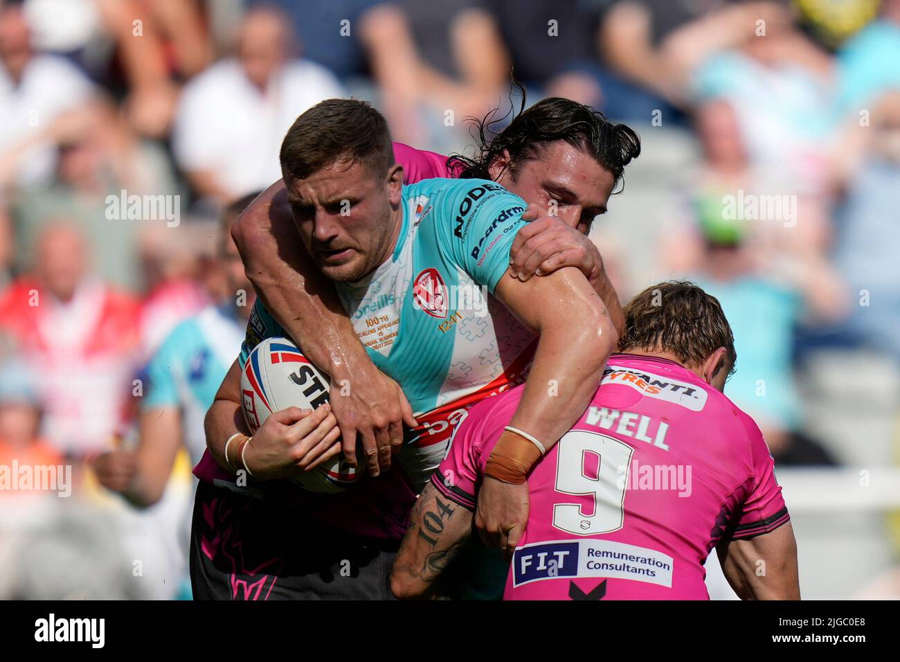 Matty Lees #10 of St Helens is held by Liam Byrne #20 and Sam Powell of ...