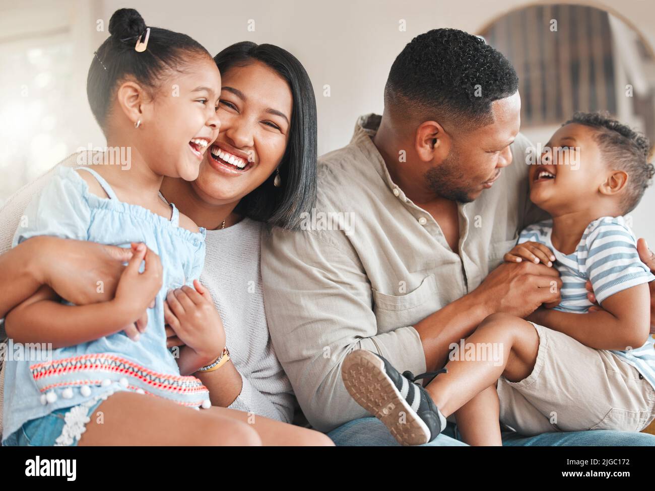 We love being home with mom and dad. a young family playing together on ...