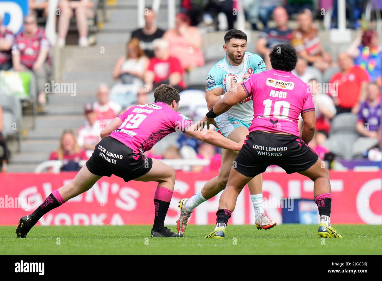 Dan Norman #24 of St Helens breaks past Ethan Havard #19 of Wigan ...