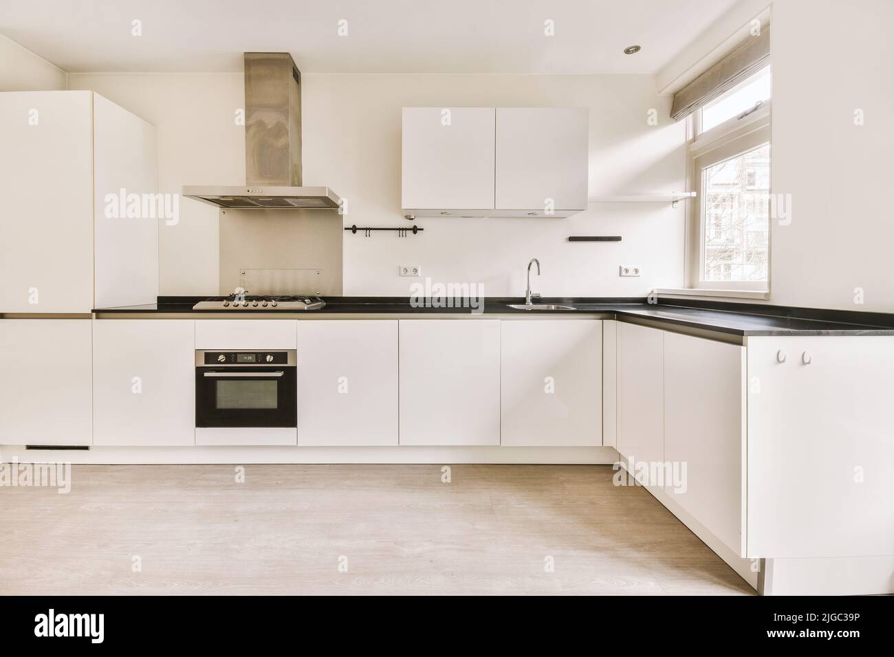 Interior of empty white kitchen with windows and wooden parquet floor ...