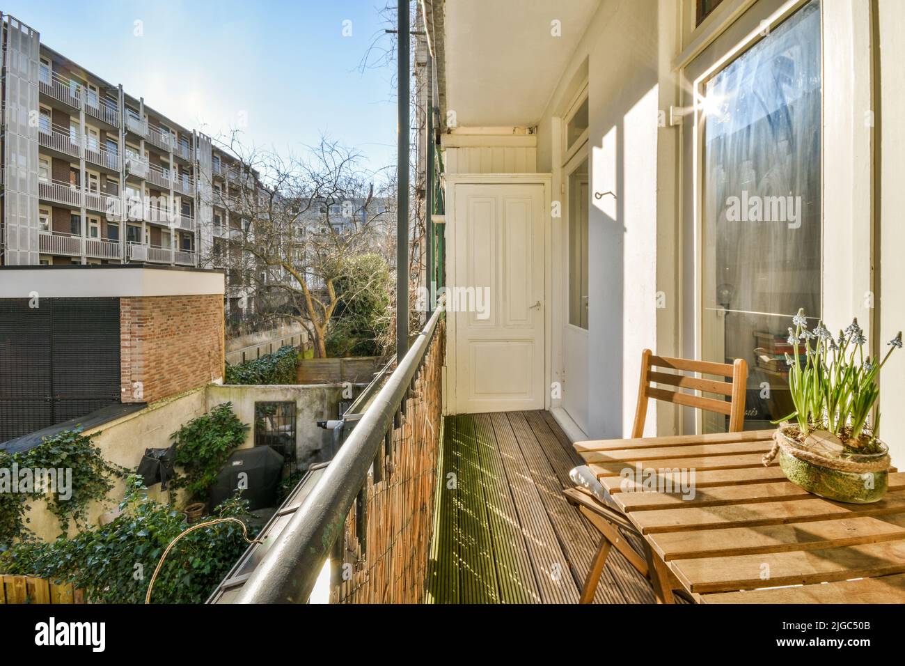 Panoramic view of old brick buildings with parking and trees from small ...