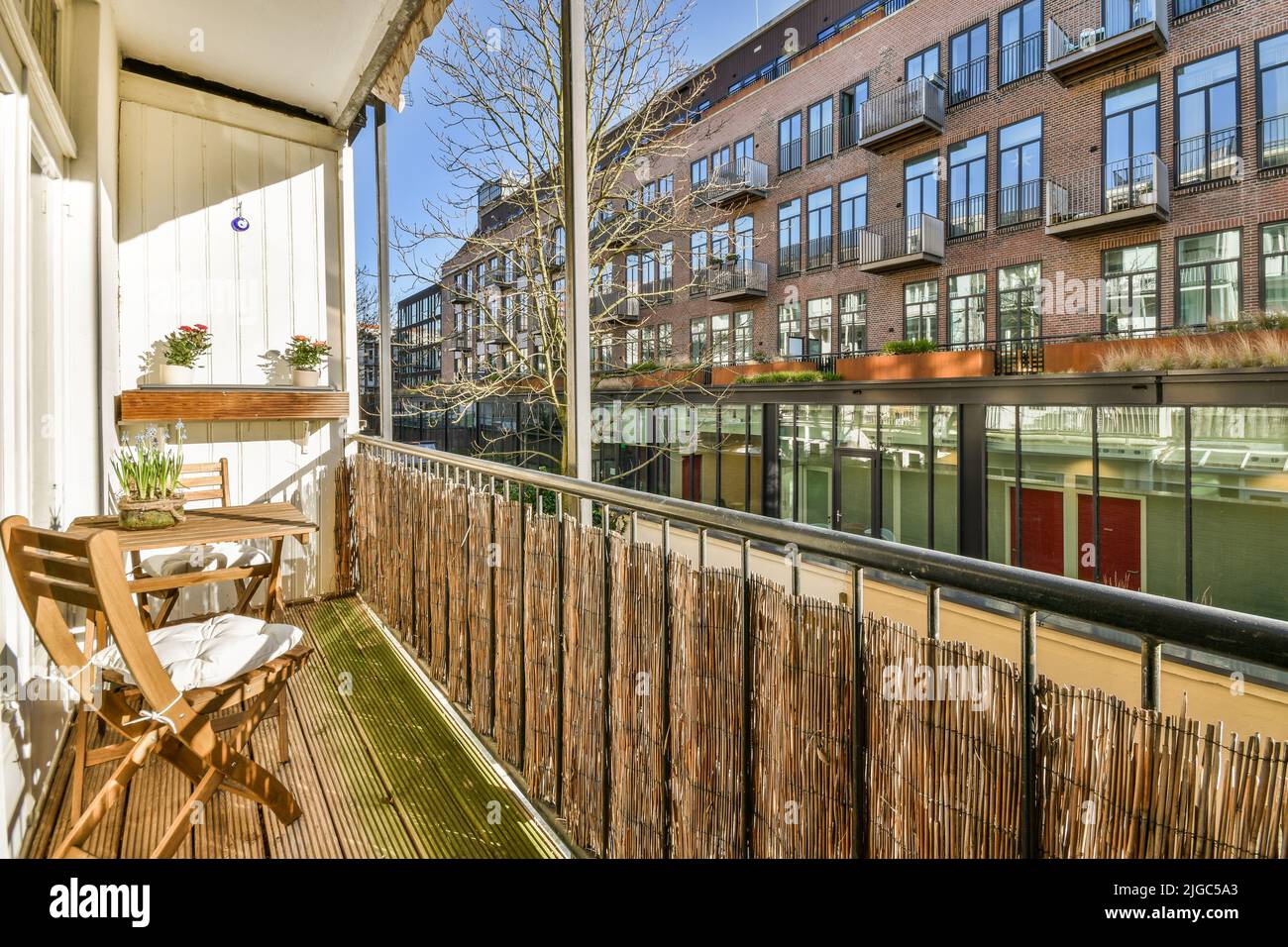 Panoramic view of old brick buildings with parking and trees from small ...