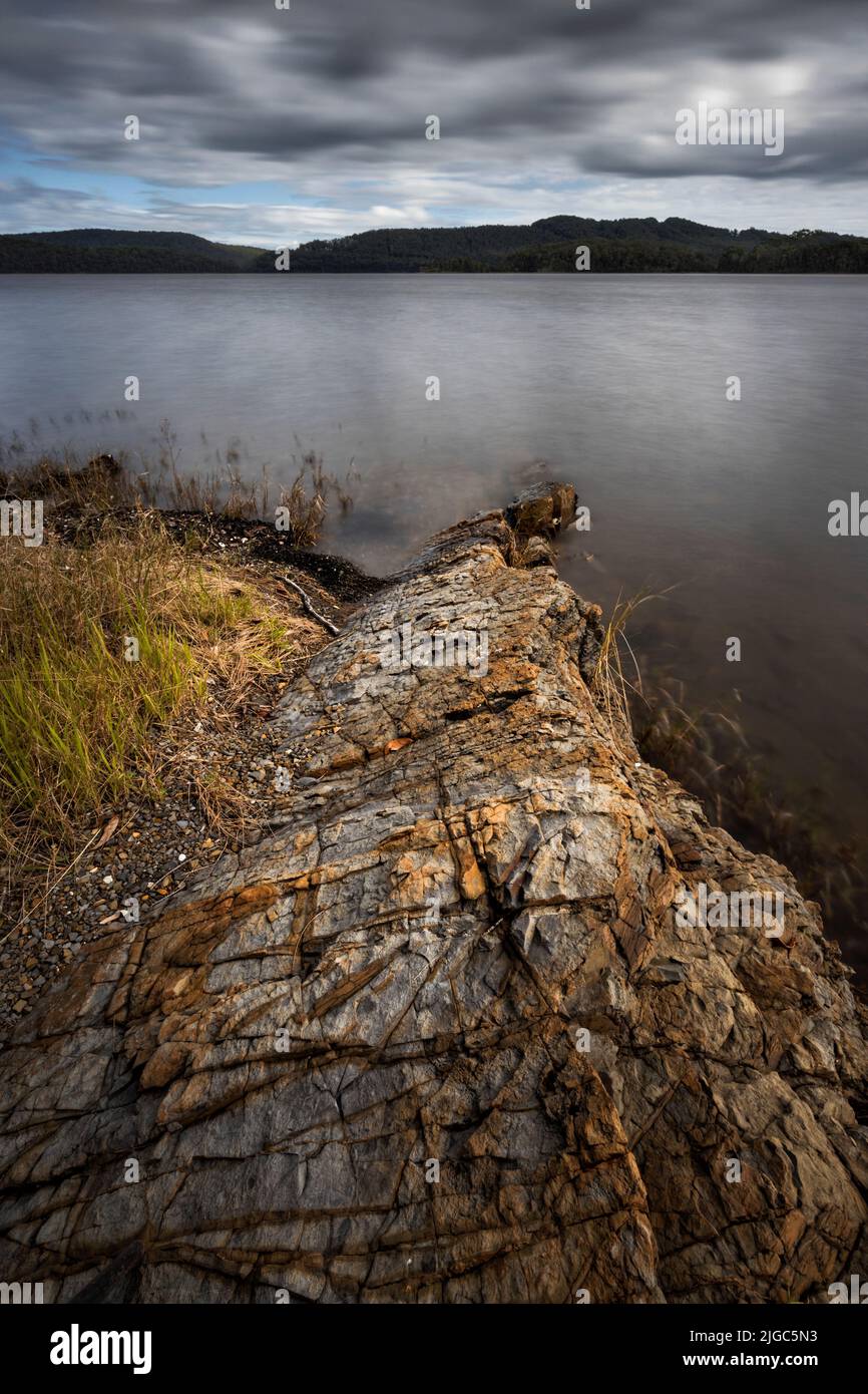 Rocks and light on the water at smiths lake in australia Stock Photo ...