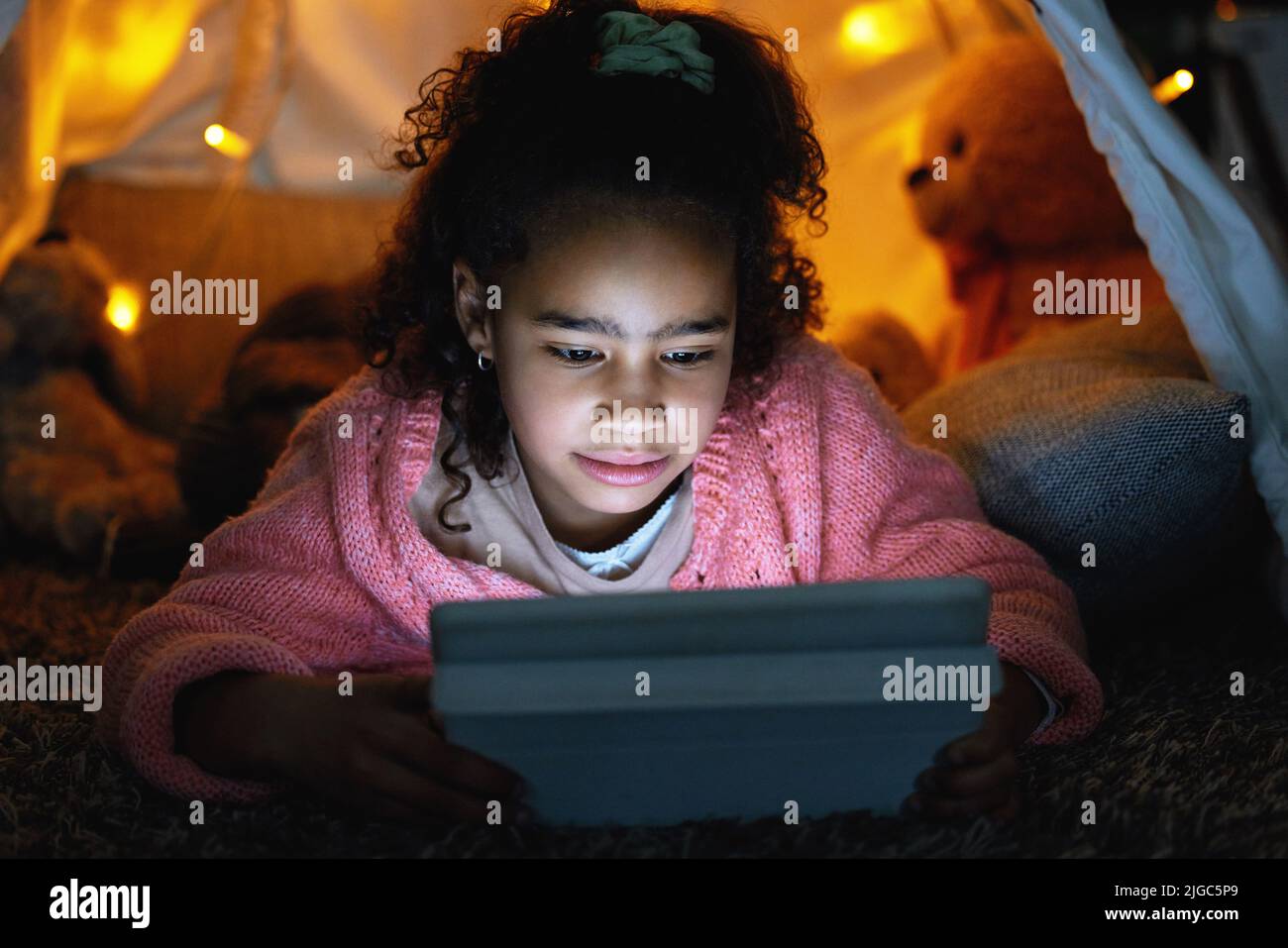 Cant miss a thing. an adorable little girl using a digital tablet ...