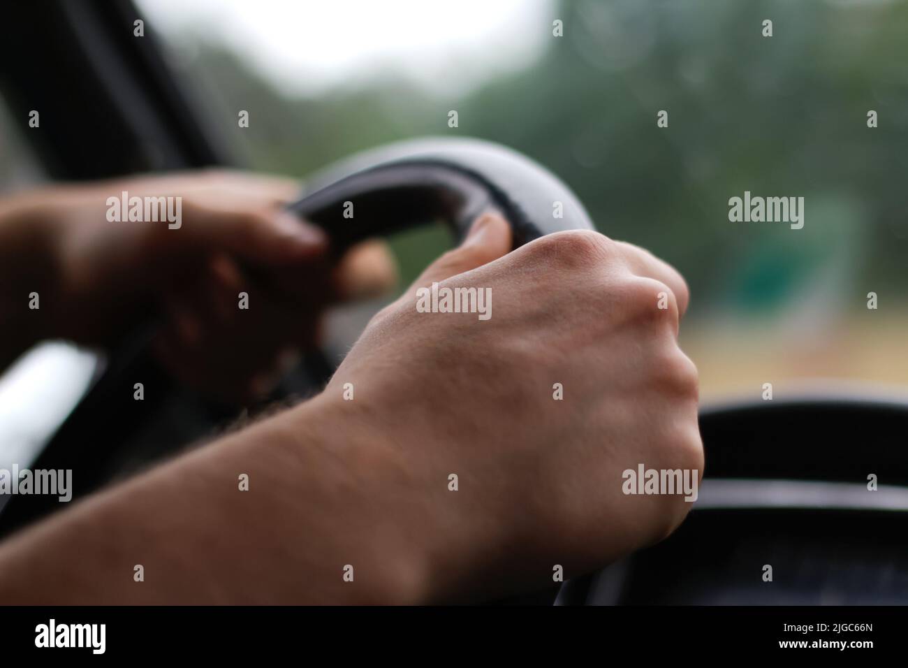 Defocus male hand holding steering wheel. A man's hand handle steering ...