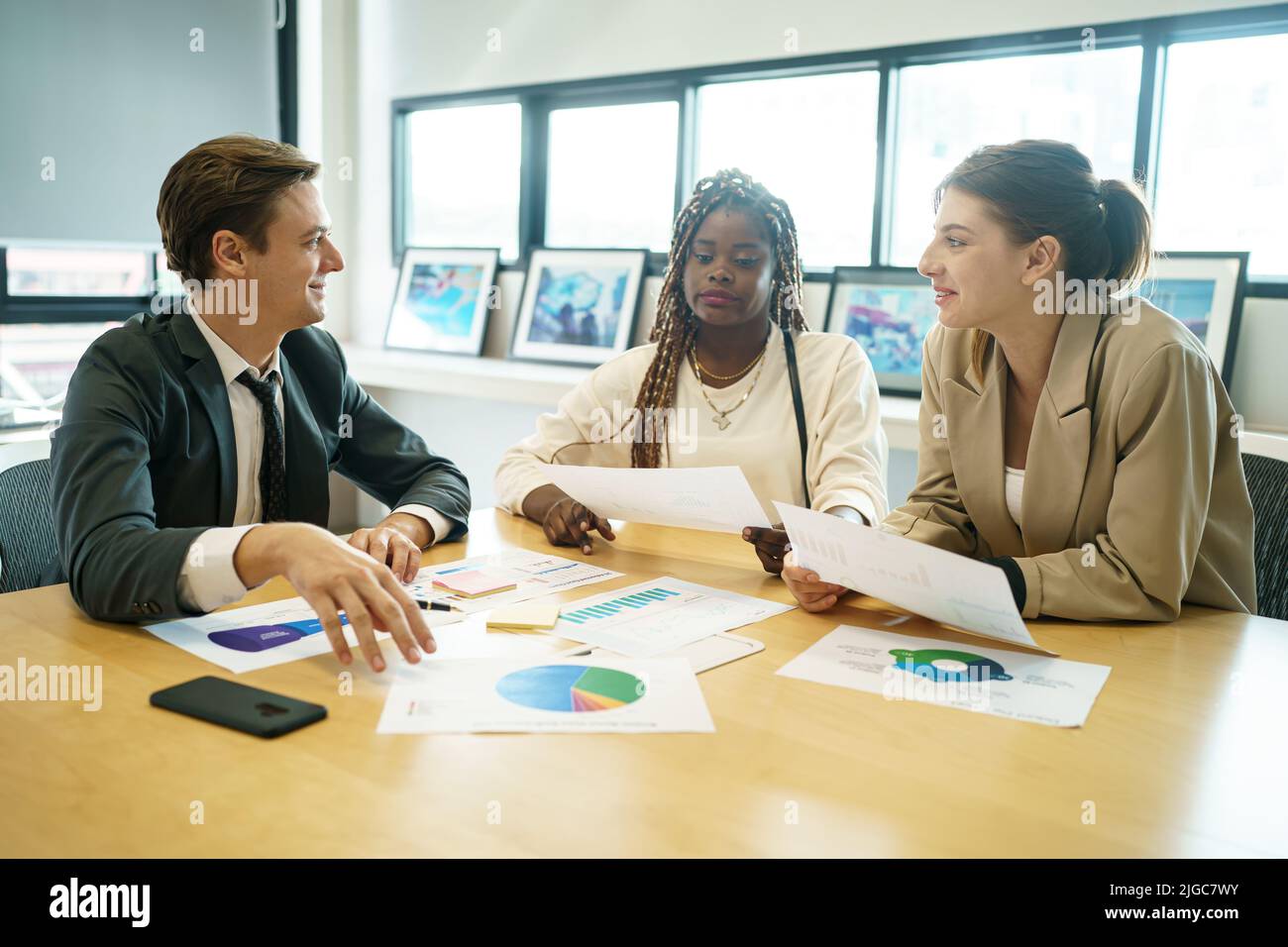 Image of young business people discussing document in paperwork data on ...