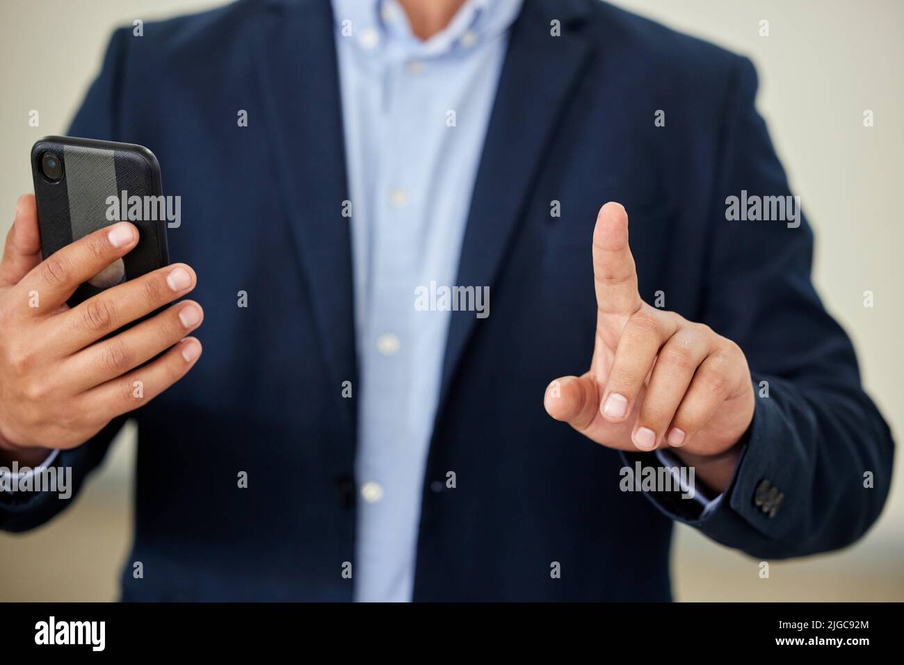 Give me one minute.... a man holding up his index finger while busy on ...