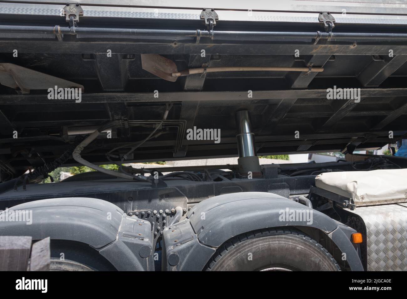 Construction site truck with loading trough tilted sideways with ...