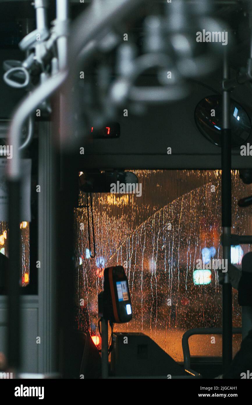 A vertical shot of an inside of a bus an empty bus with raindrops on ...