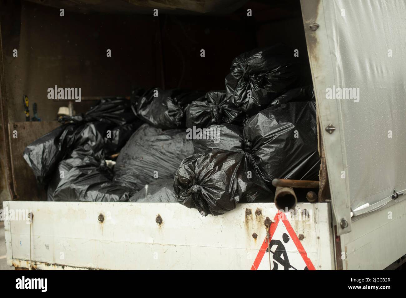 Bags of garbage in car. Black packages in back of car. Transportation ...