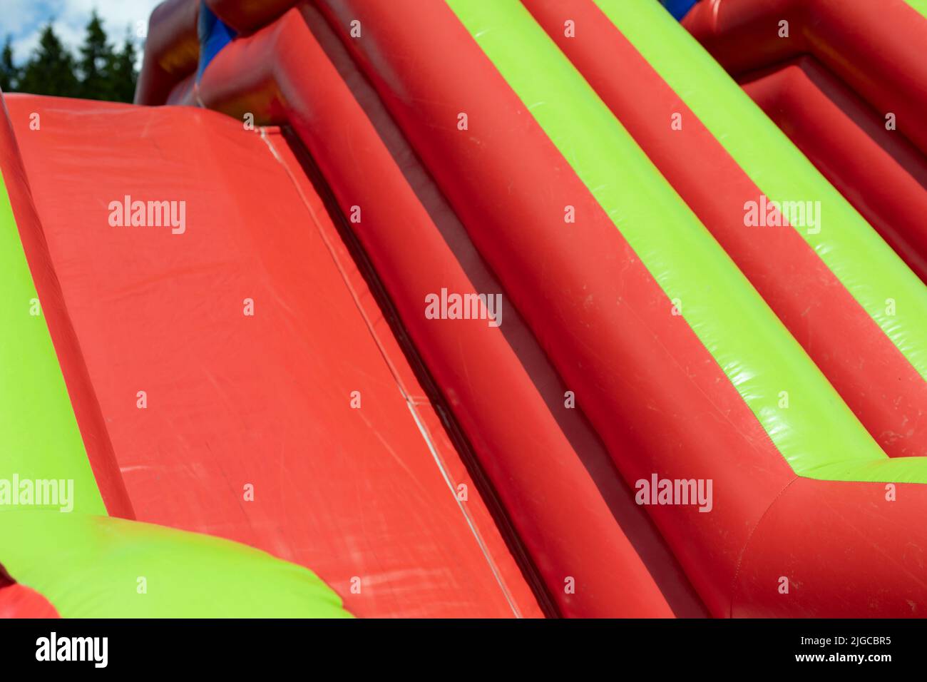 Inflatable slide of red color. Obstacle course in summer. Amusement ...