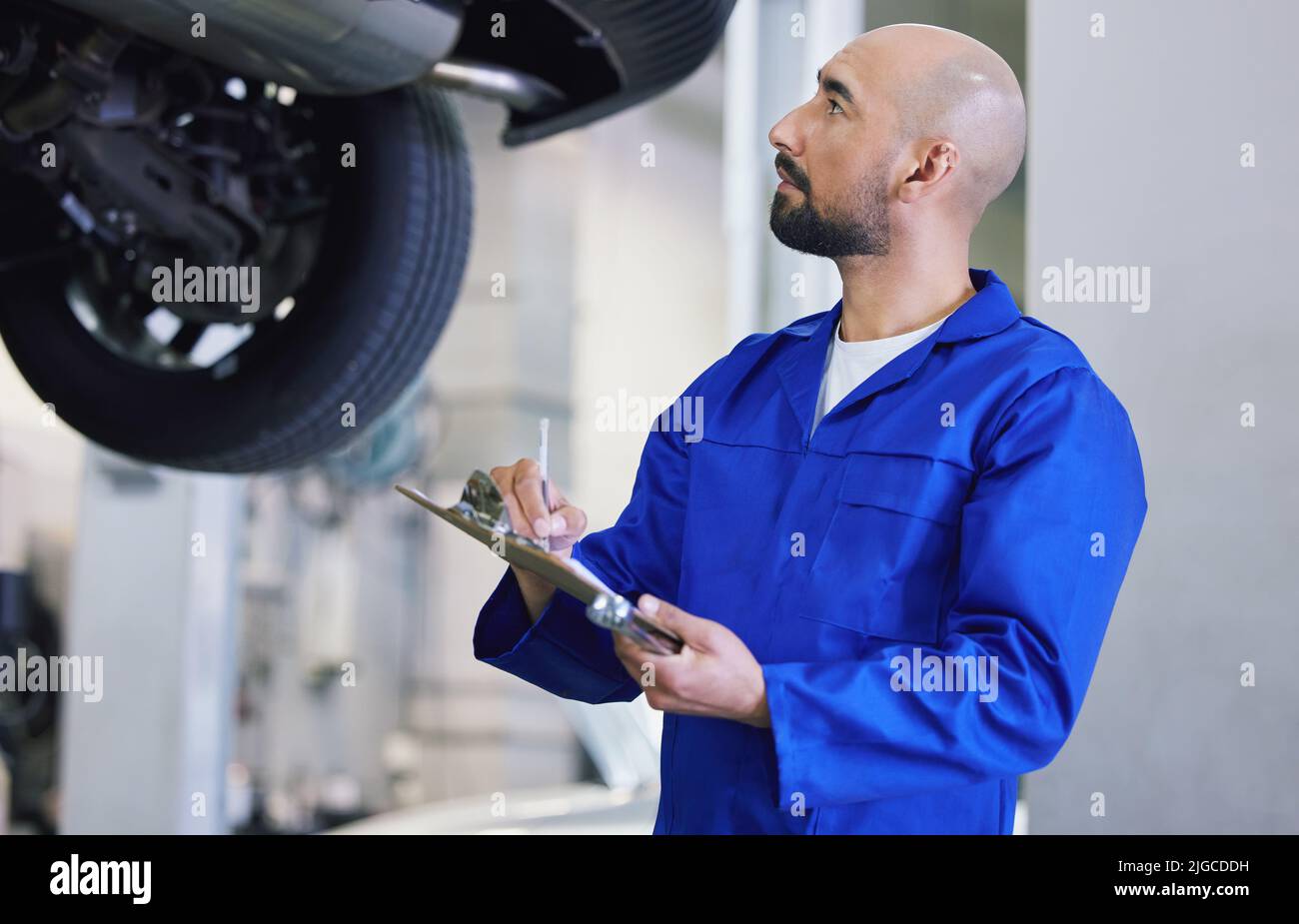 Putting your car to the test. a handsome young male mechanic working on ...