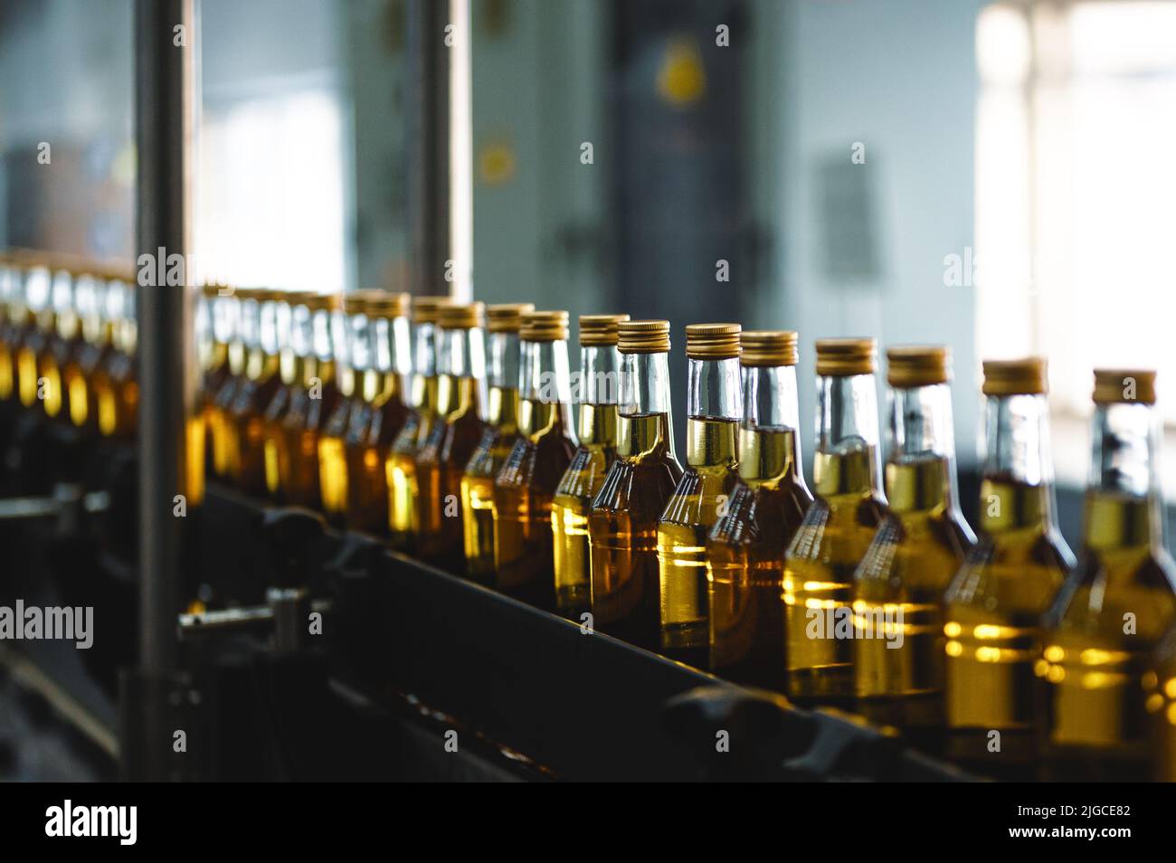 Alcohol liquor closed bottles with caps at production line Stock Photo ...
