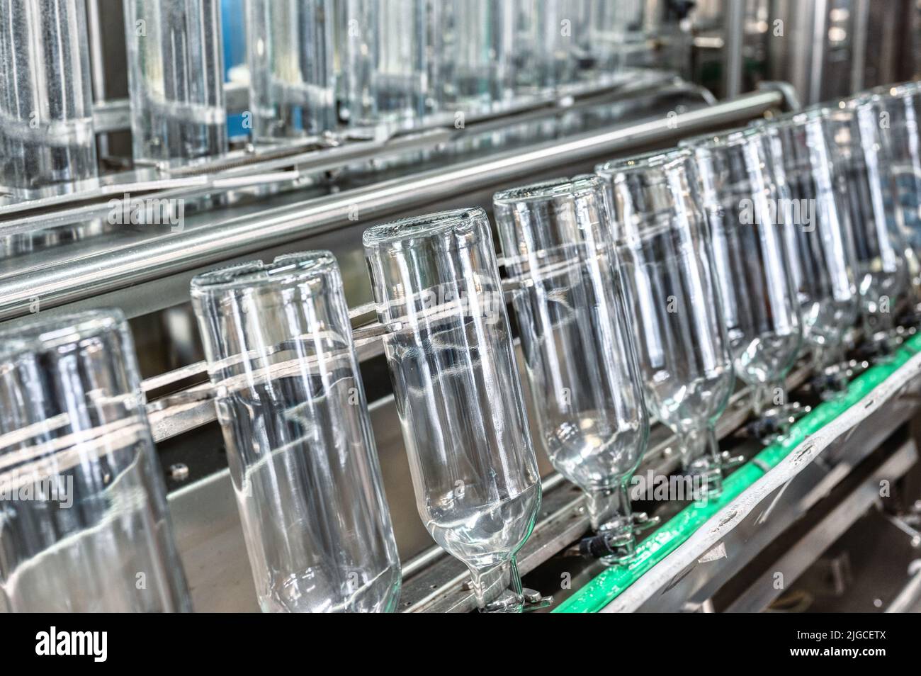 Row of empty glass bottles on automatic conveyor at plant Stock Photo ...