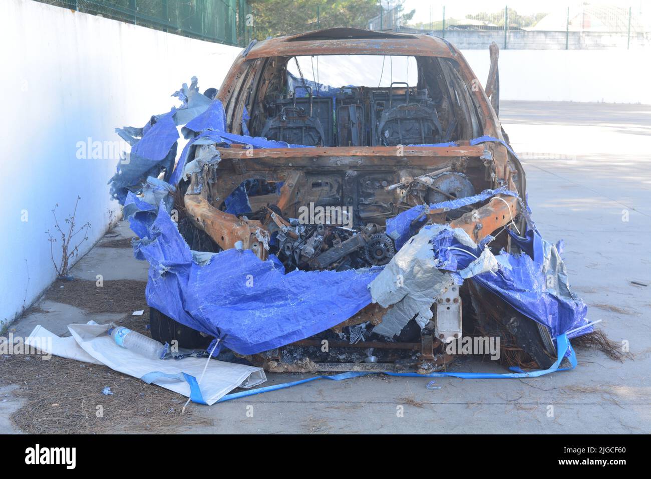 Acar totally wrecked with a blue cloth around it Stock Photo - Alamy