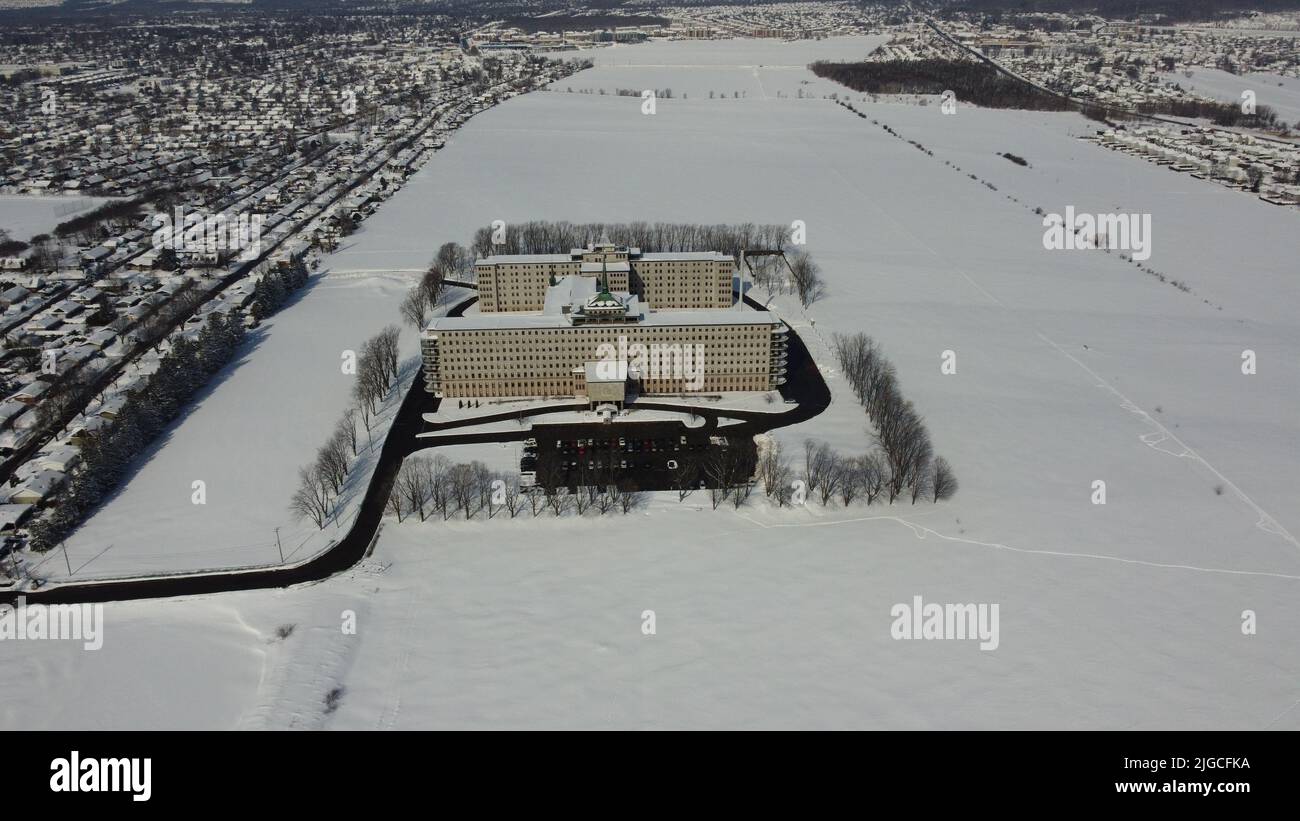 An aerial view of a huge building surrounded by white snow in a rural ...