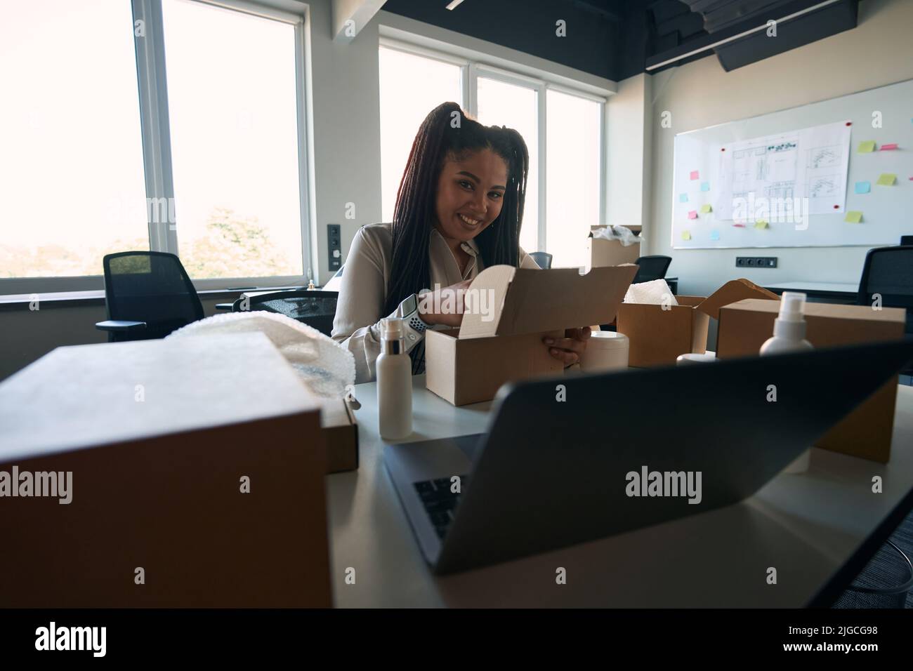 Internet shop employee placing merchandise into cardboard box Stock ...
