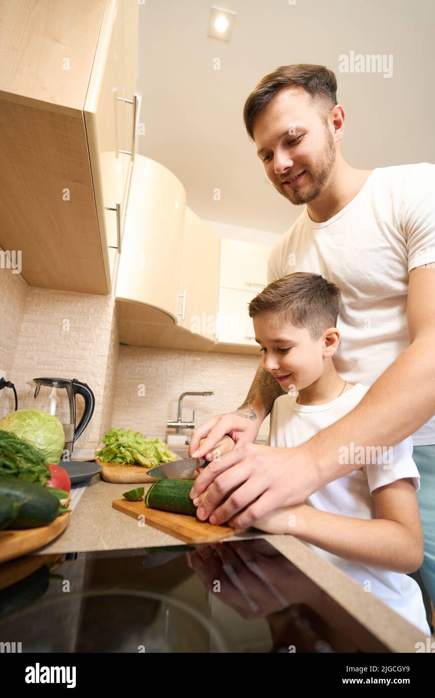 Caring father teaching his son to cut vegetables Stock Photo - Alamy