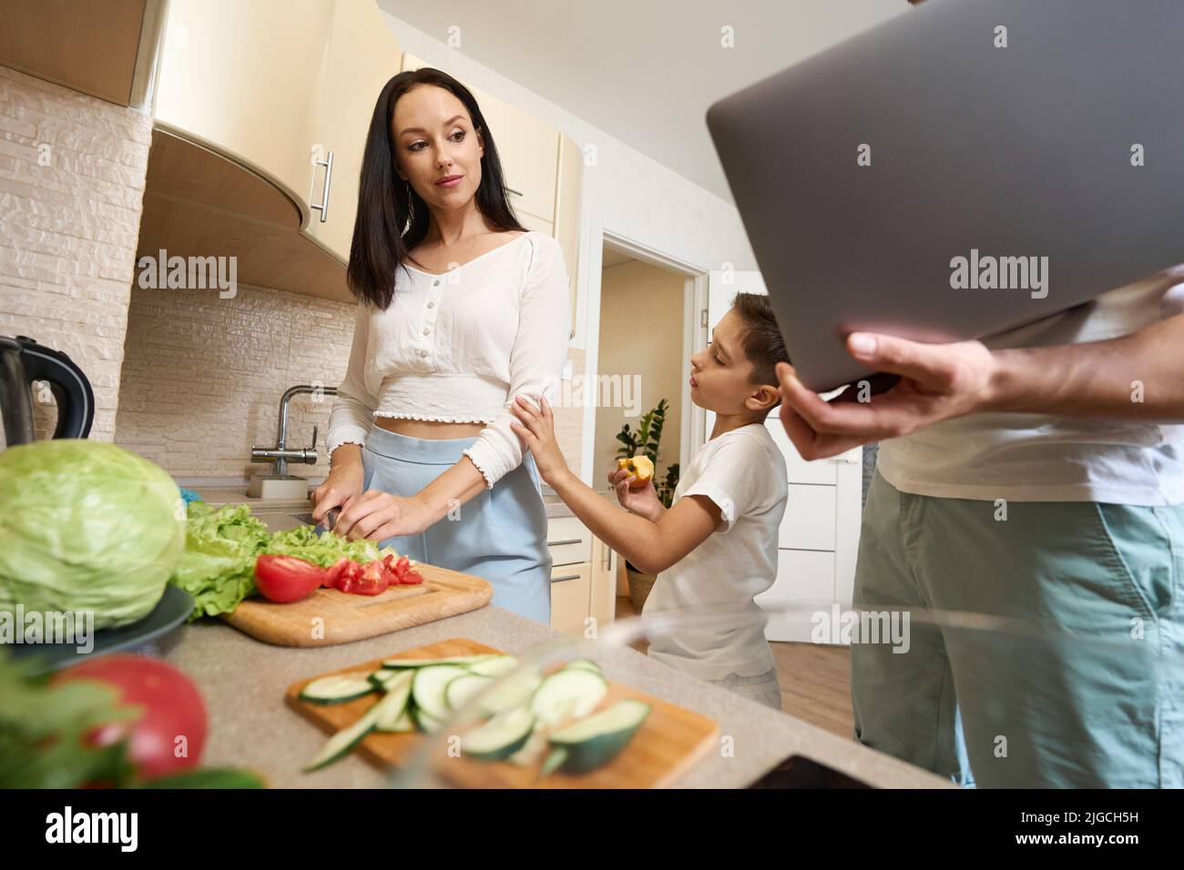 Mother cooking in kitchen getting distracted by husband and son Stock ...