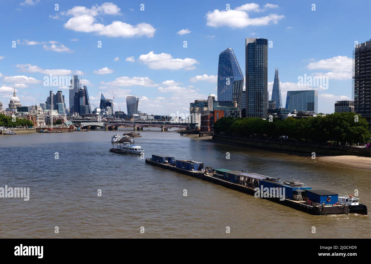 Boats moored on a floating pontoon dock along the River THames with the ...