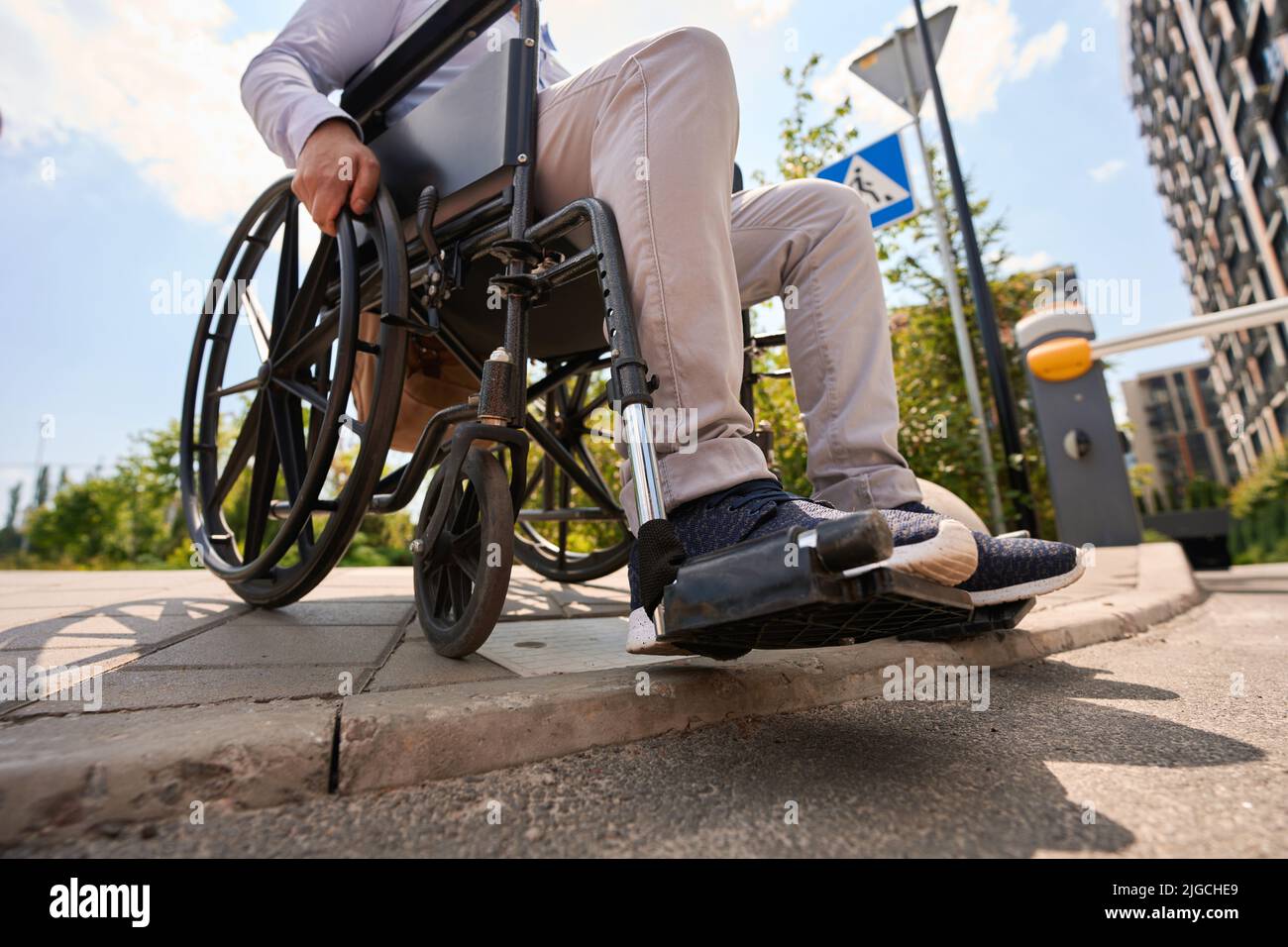 Disabled man going down curb in manual wheelchair Stock Photo - Alamy