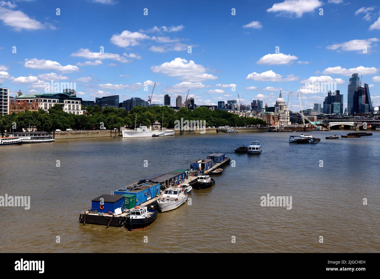 Boats moored on a floating pontoon dock along the River THames with the ...