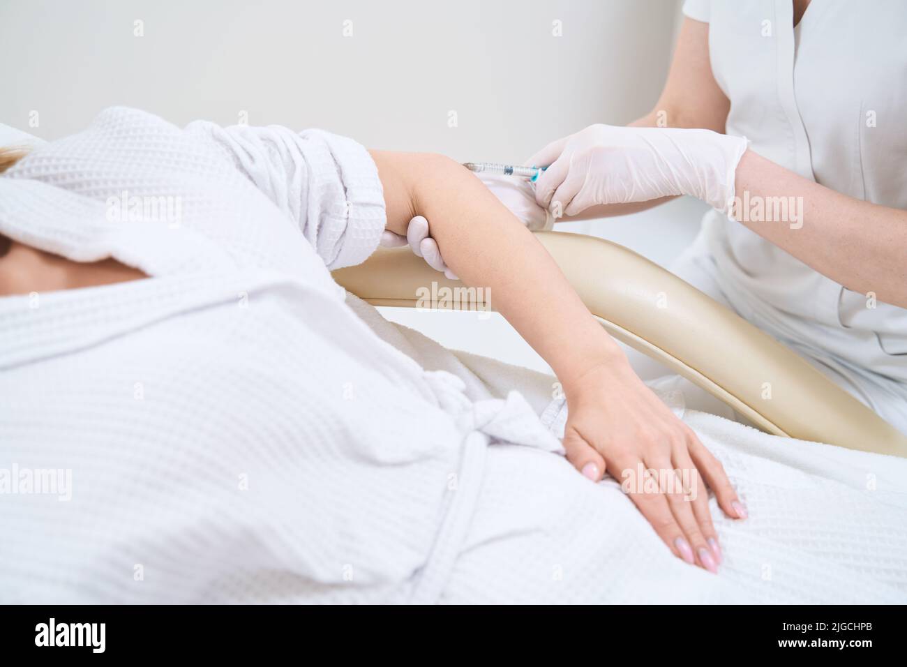 Medical worker gives an injection to a patient to tighten the skin of ...