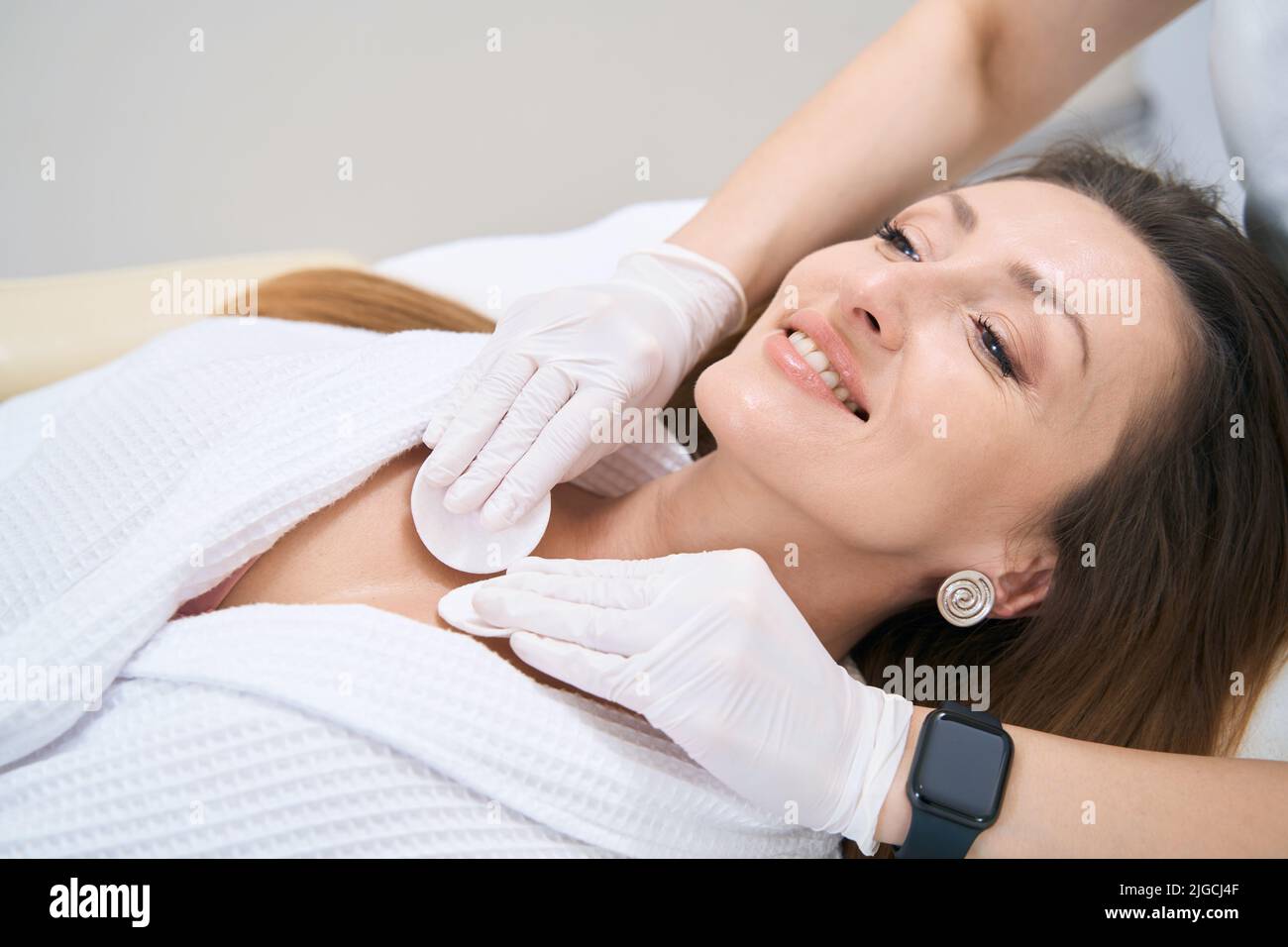 Dermatologist cleans patient skin with cotton swabs in the neck and ...