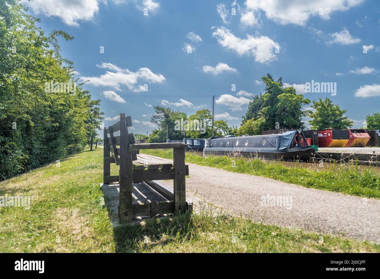 Nantwich Canal bench and stationary narrowboat sunny day landscape ...