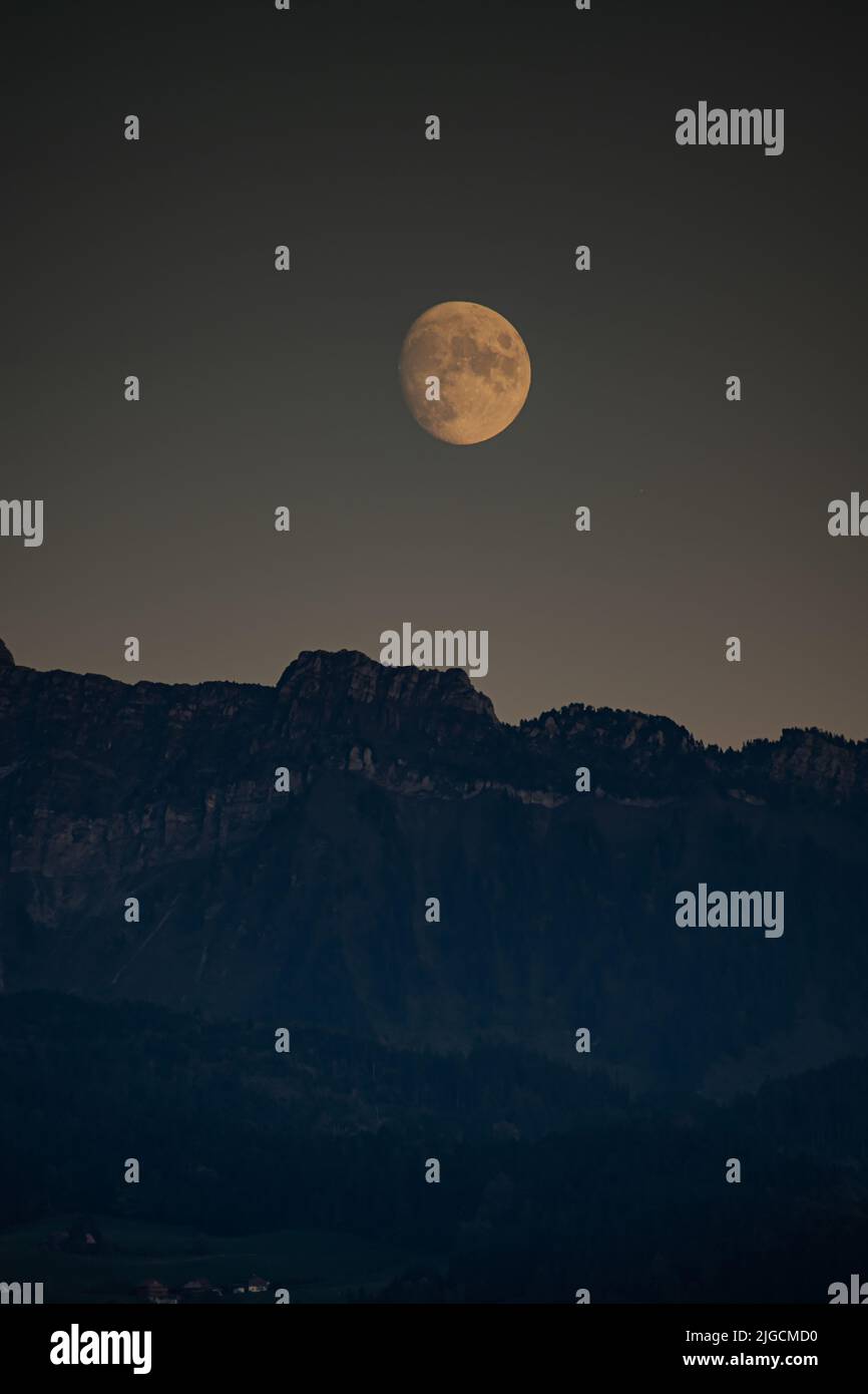 Full moon rise infront of swiss mountains Stock Photo - Alamy