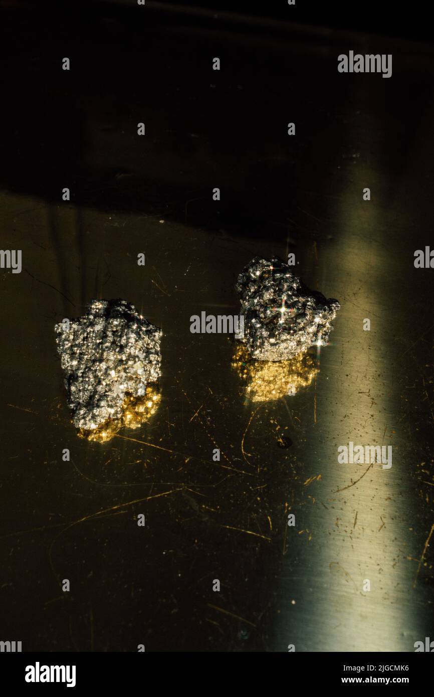 Sparkling pyrite, fool's gold crystal geode rock on brass reflective ...