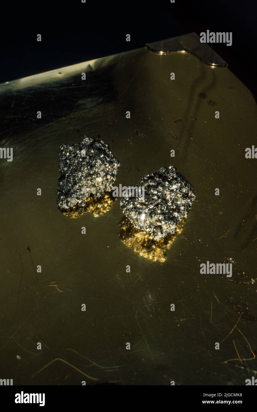 sparkling pyrite, fool's gold crystal geode rock on brass reflective ...