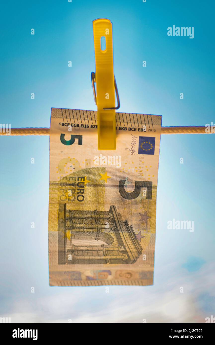 A 5 euro bill hanging on a string with a clothespin - money laundering ...