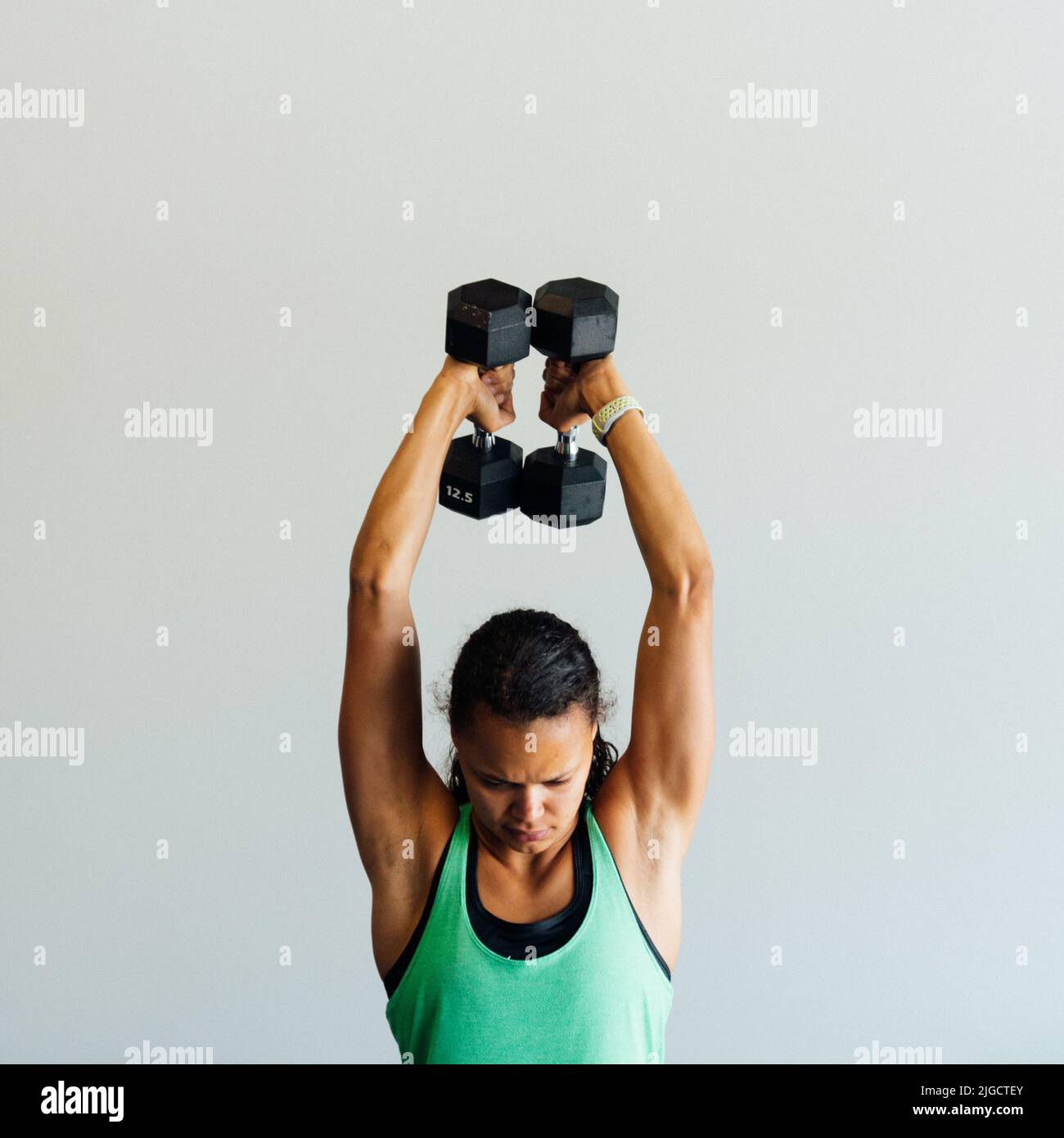 An African American woman lifting weights overhead Stock Photo - Alamy