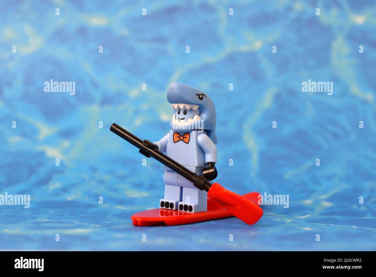 Toy male smiling figure, boy shark, paddle boarding in the ocean Stock ...