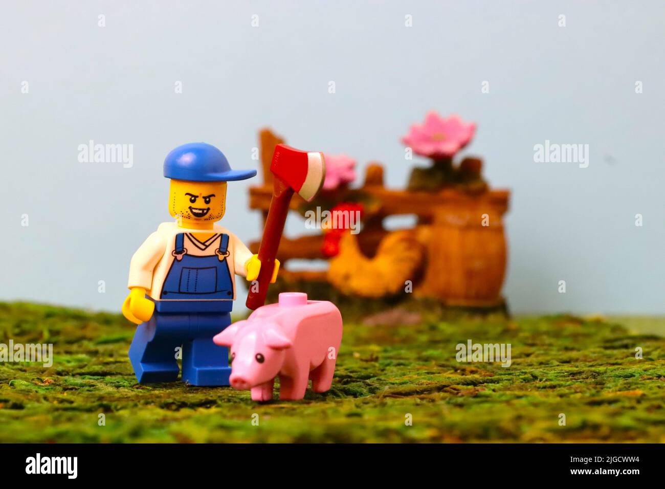 Toy male figure. Character wearing blue overalls on a farm, chasing a ...